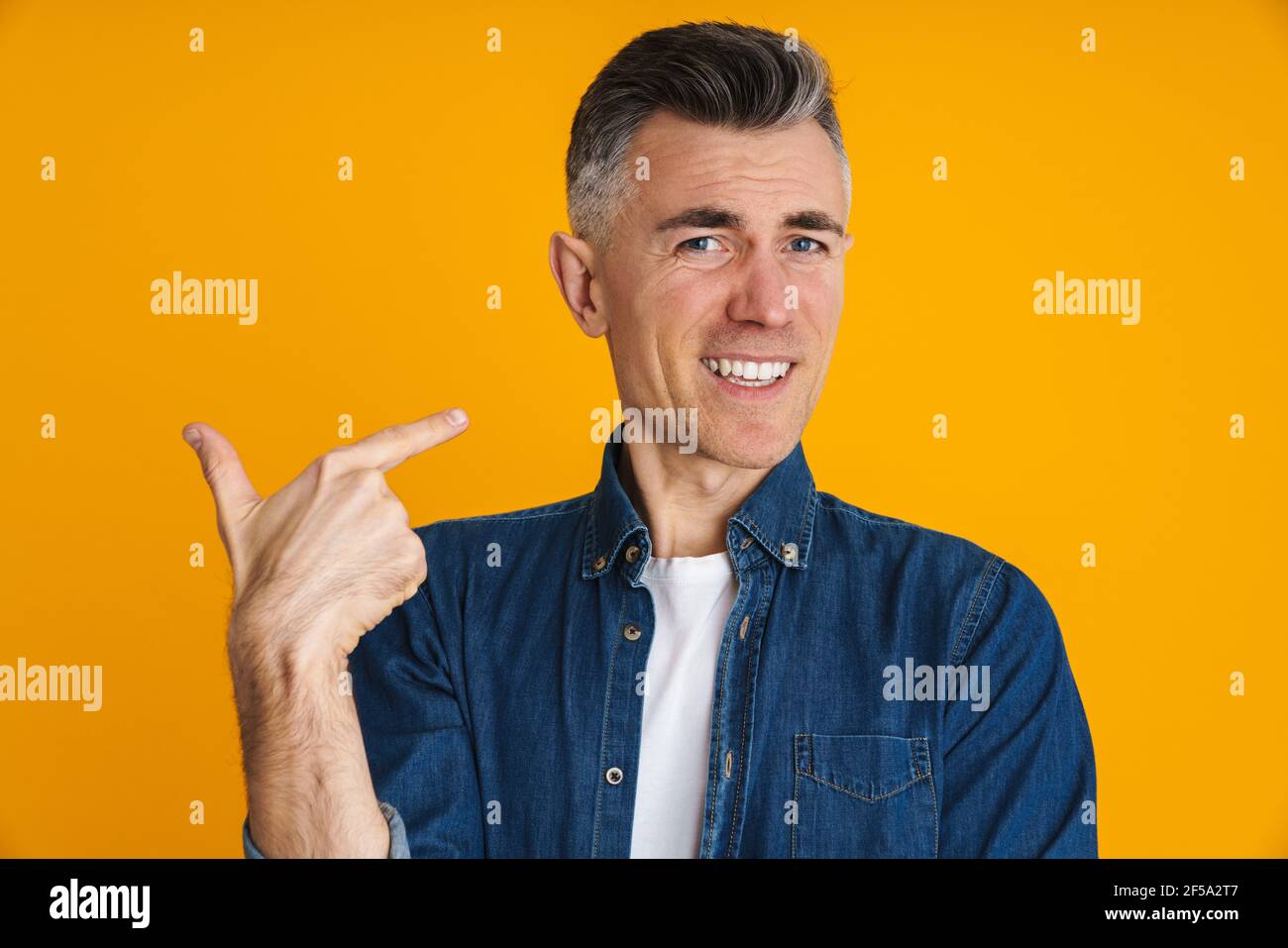 Confused handsome man posing and pointing fingers at himself isolated ...