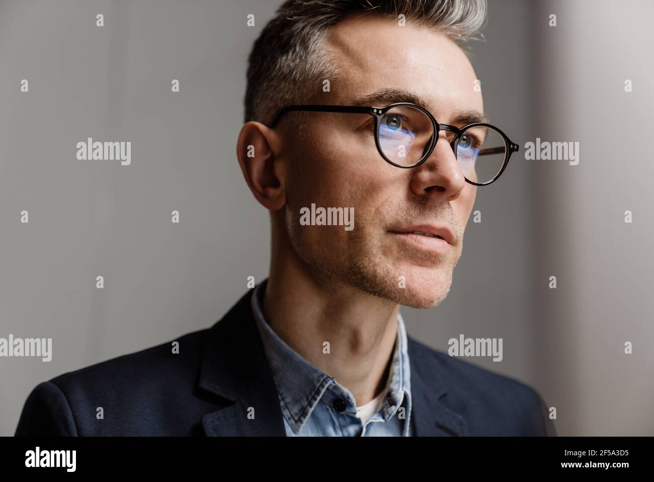 Serious grey man wearing eyeglasses thinking and looking forward in ...