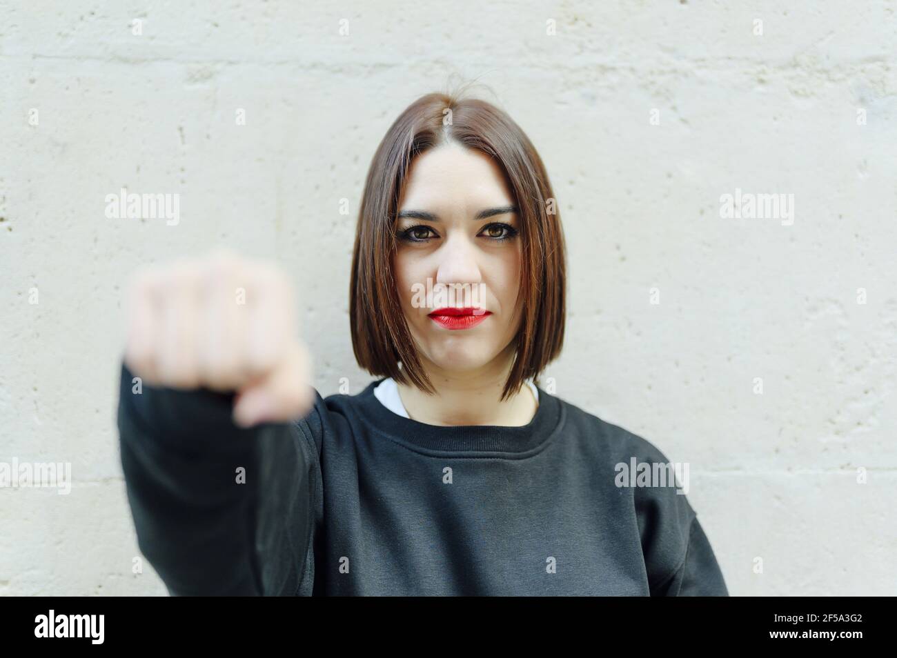 Young Spanish woman has stretched her fist forward as a symbol of women ...