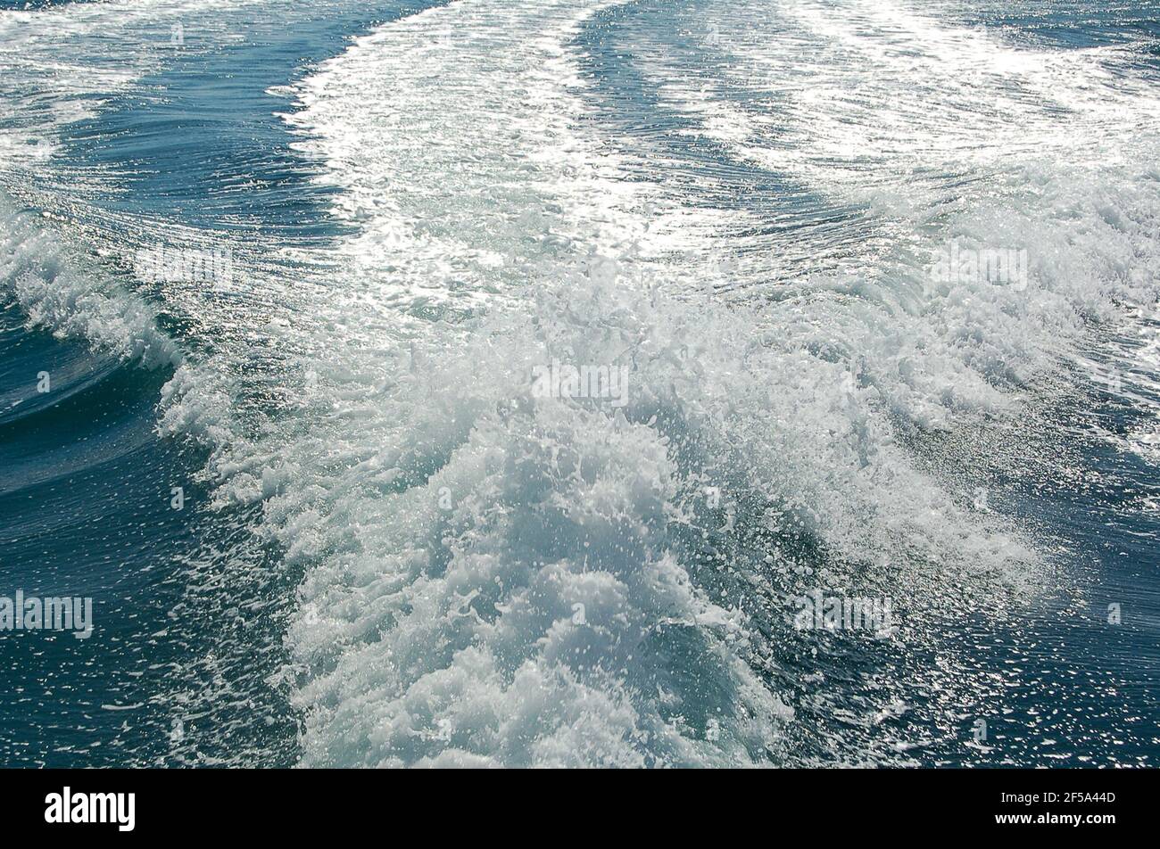 Powerful water stream after speed motorboat. Trail on water surface ...