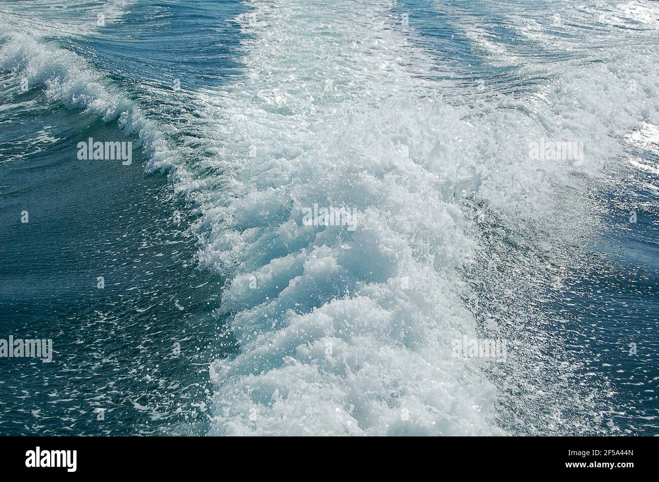 Powerful water stream after speed motorboat. Trail on water surface ...