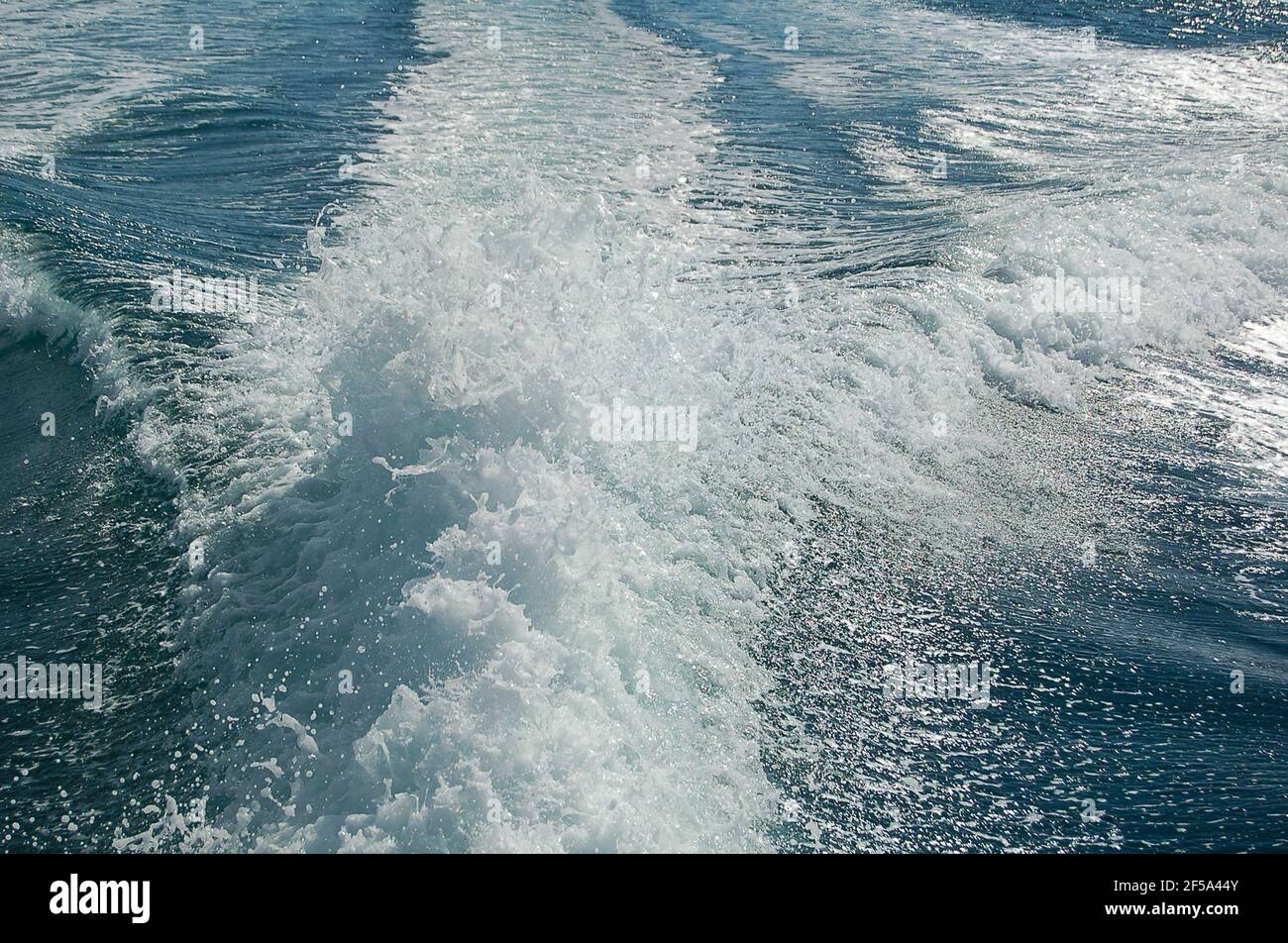 Powerful water stream after speed motorboat. Trail on water surface ...