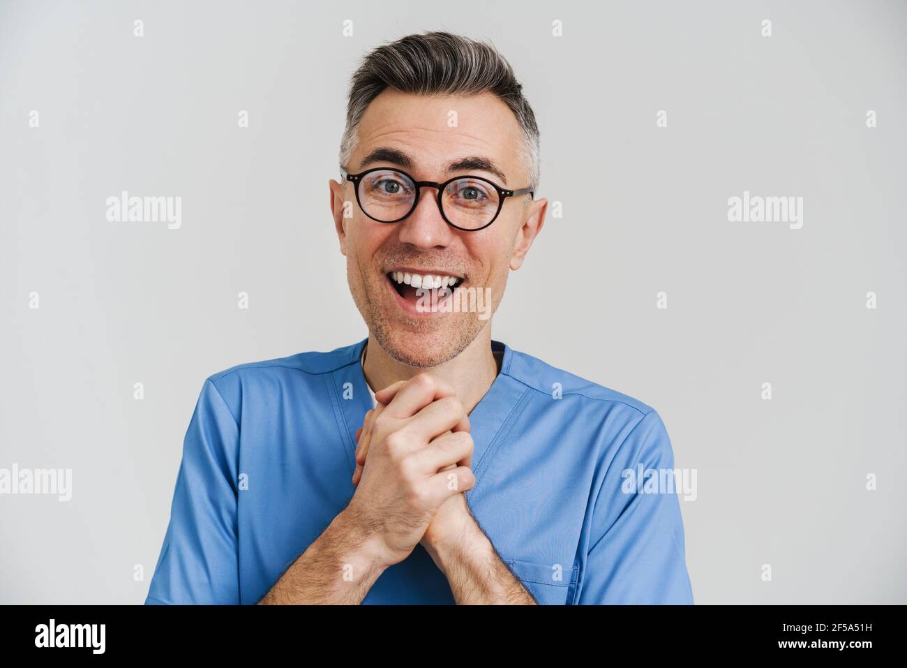 Excited white-haired medical doctor exclaiming and looking at camera ...