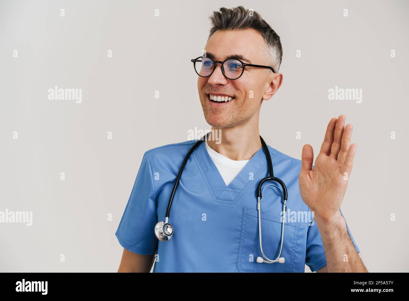 Happy white-haired medical doctor with stethoscope smiling and waving ...