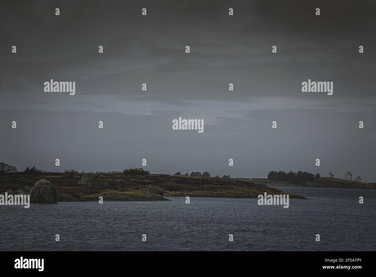 Dramatic and moody view of a calm sea under a gloomy sky background ...