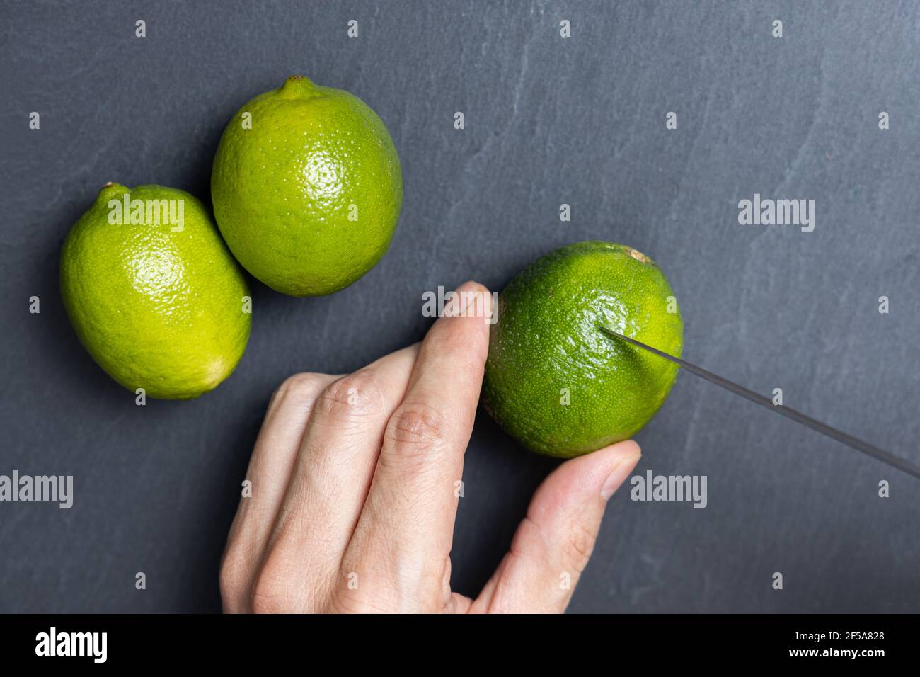 Man cutting a lime with a knife Stock Photo - Alamy