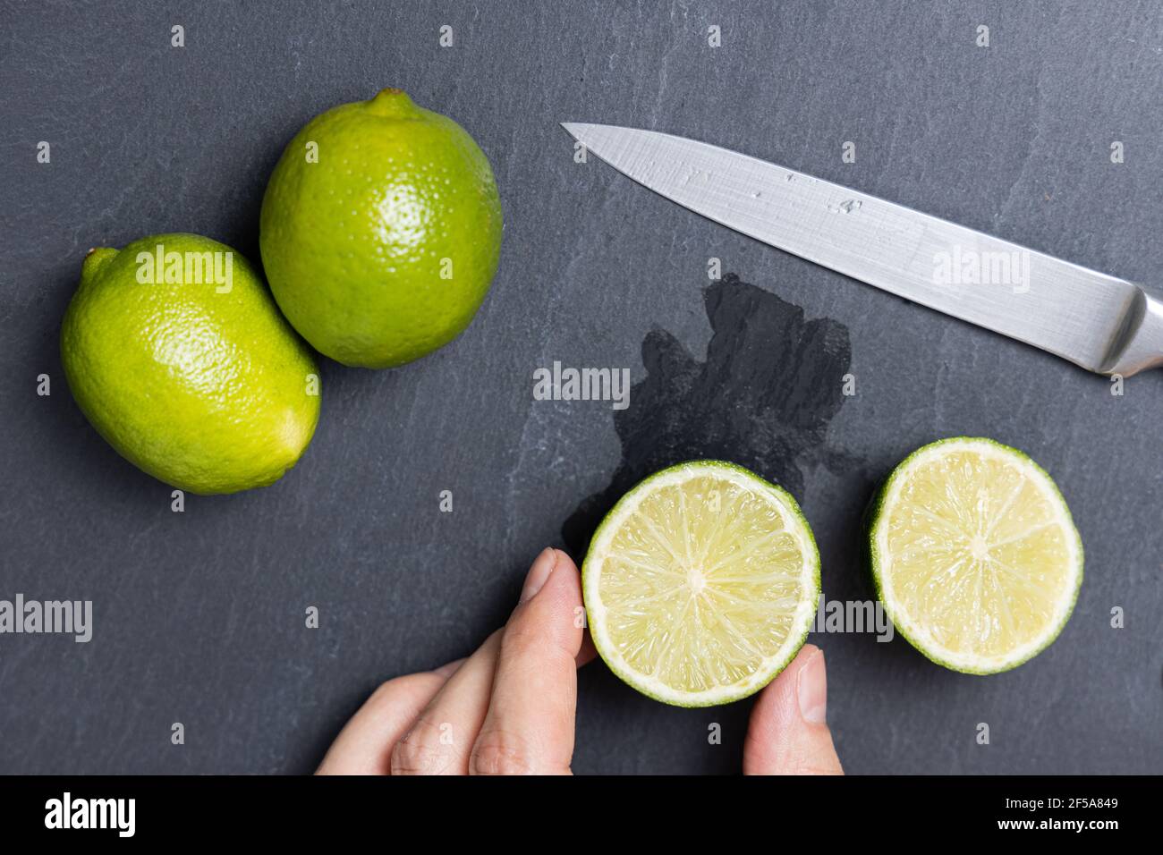 Sliced lime and knife on a slate plate Stock Photo - Alamy