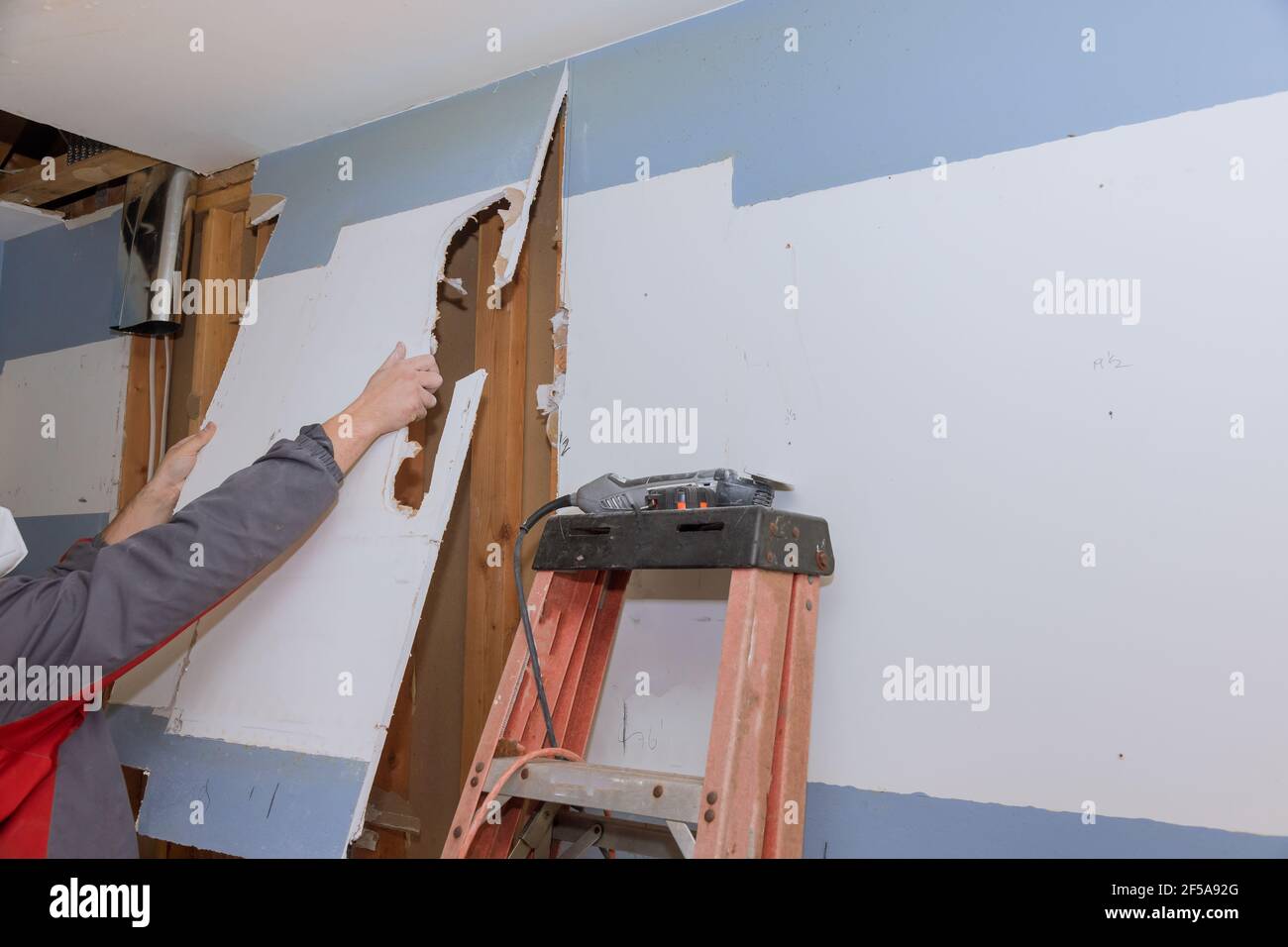 Kitchen renovation in progress with removed old sheetrock preparing for new cabinet installation ...