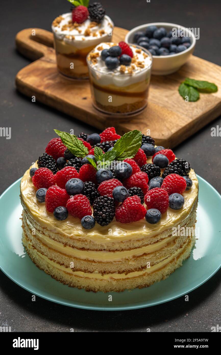Homemade cake with fresh berries and sweet desserts on dark background ...