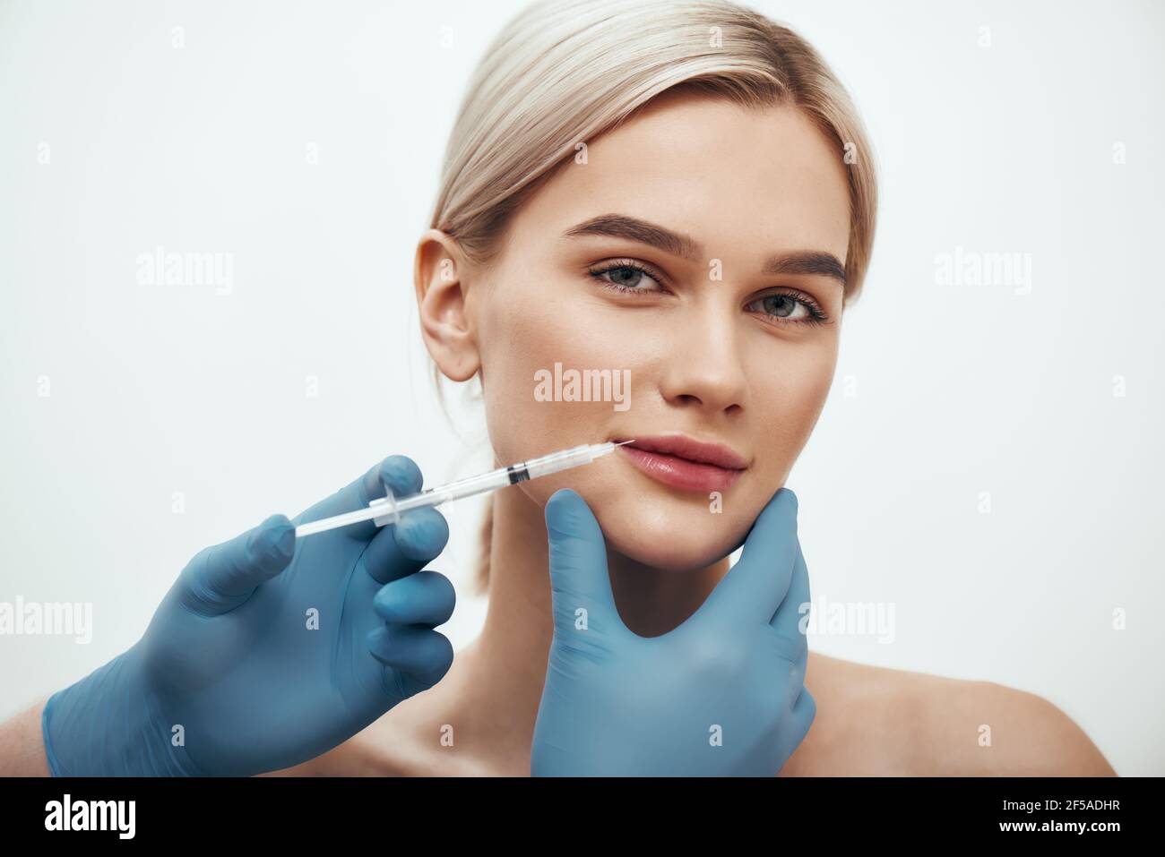 Cosmetic injection. Young beautiful woman looking at camera and smiling ...