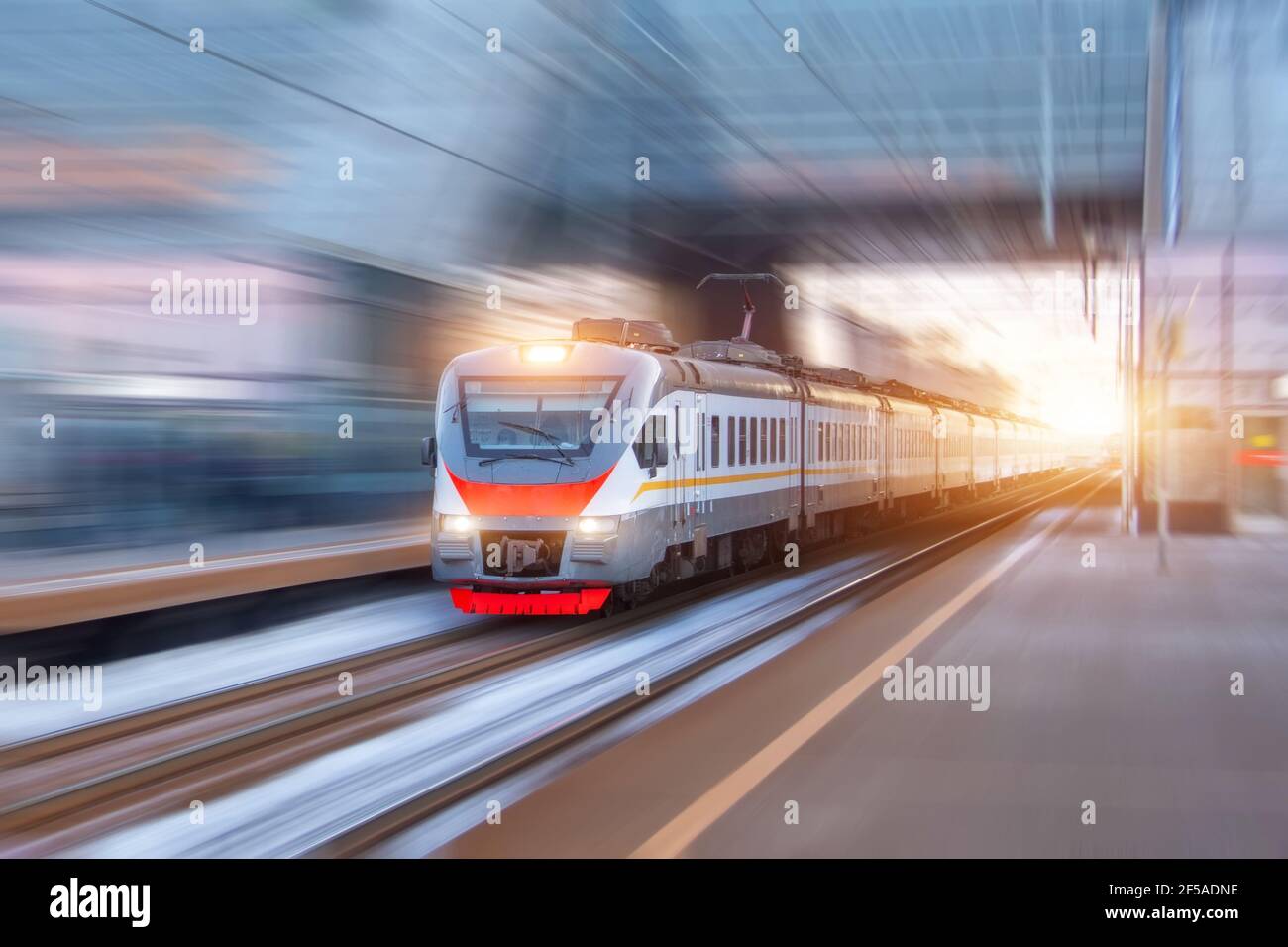 Speed suburban train with motion blur rides city station Stock Photo ...