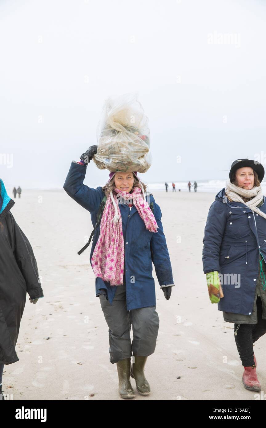 Mature Woman Balancing Trash Bag On Head After CleanUp in Beach Stock ...
