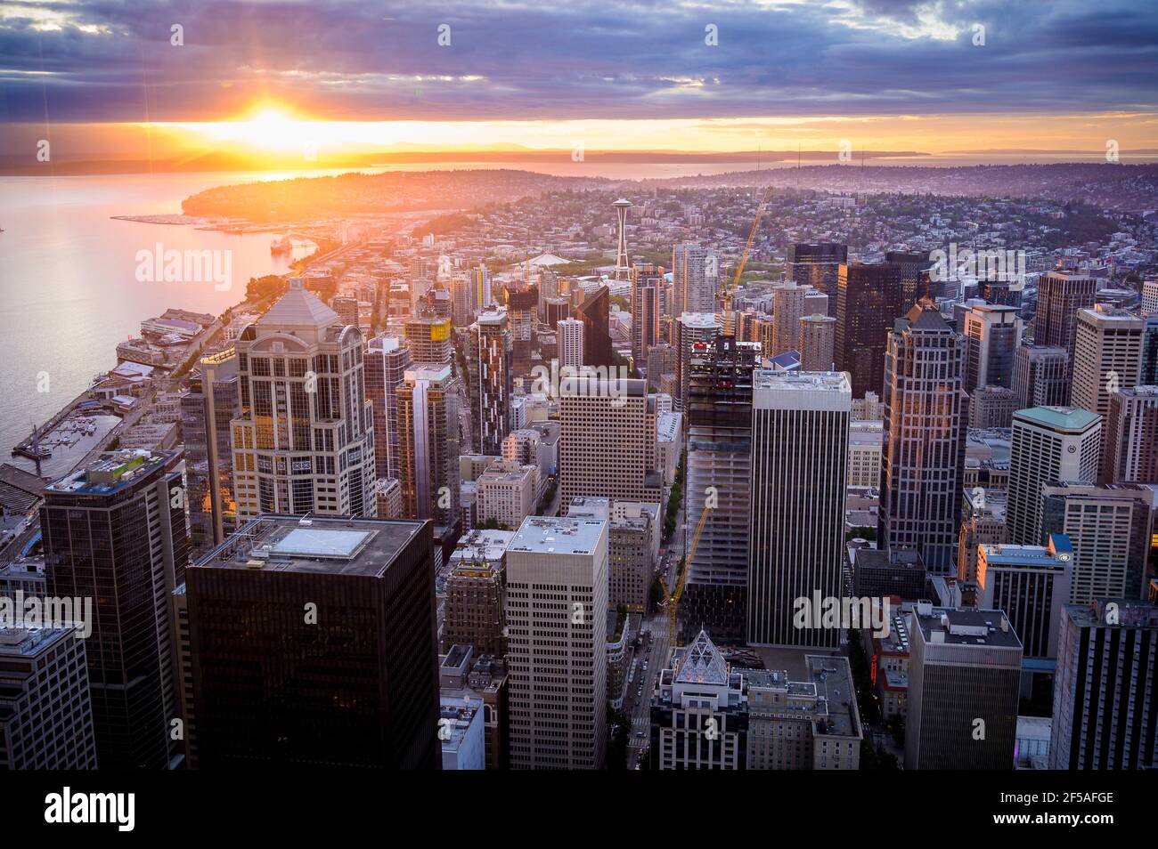 Seattle Skyline At Sunset With Sun Peaking Through The Clouds Stock ...