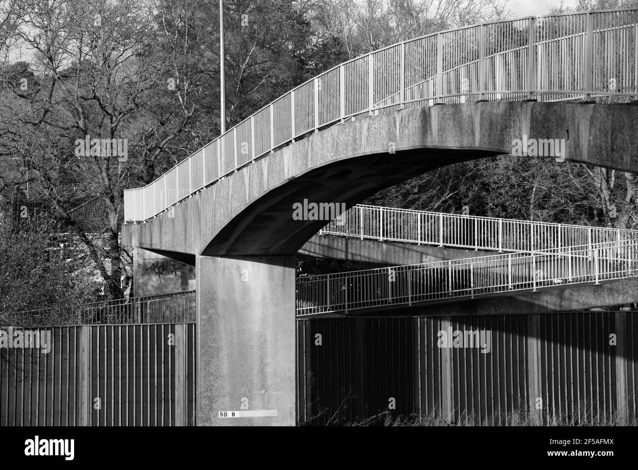 A footbridge over the M3 motorway in Surrey is shown in this black and ...