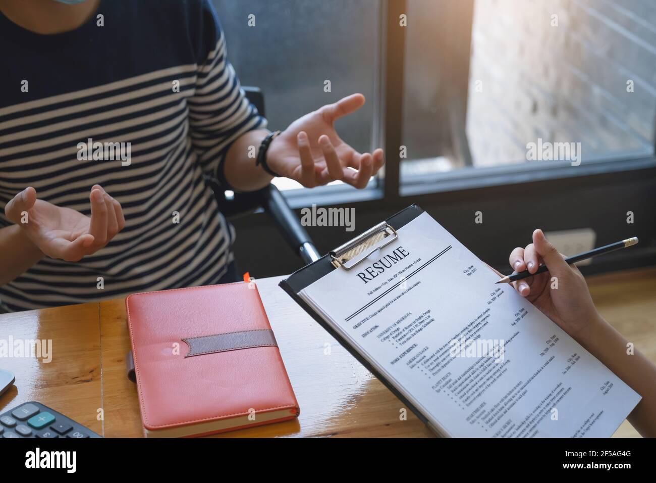 Businesswoman reading resume of man on document during an interview ...