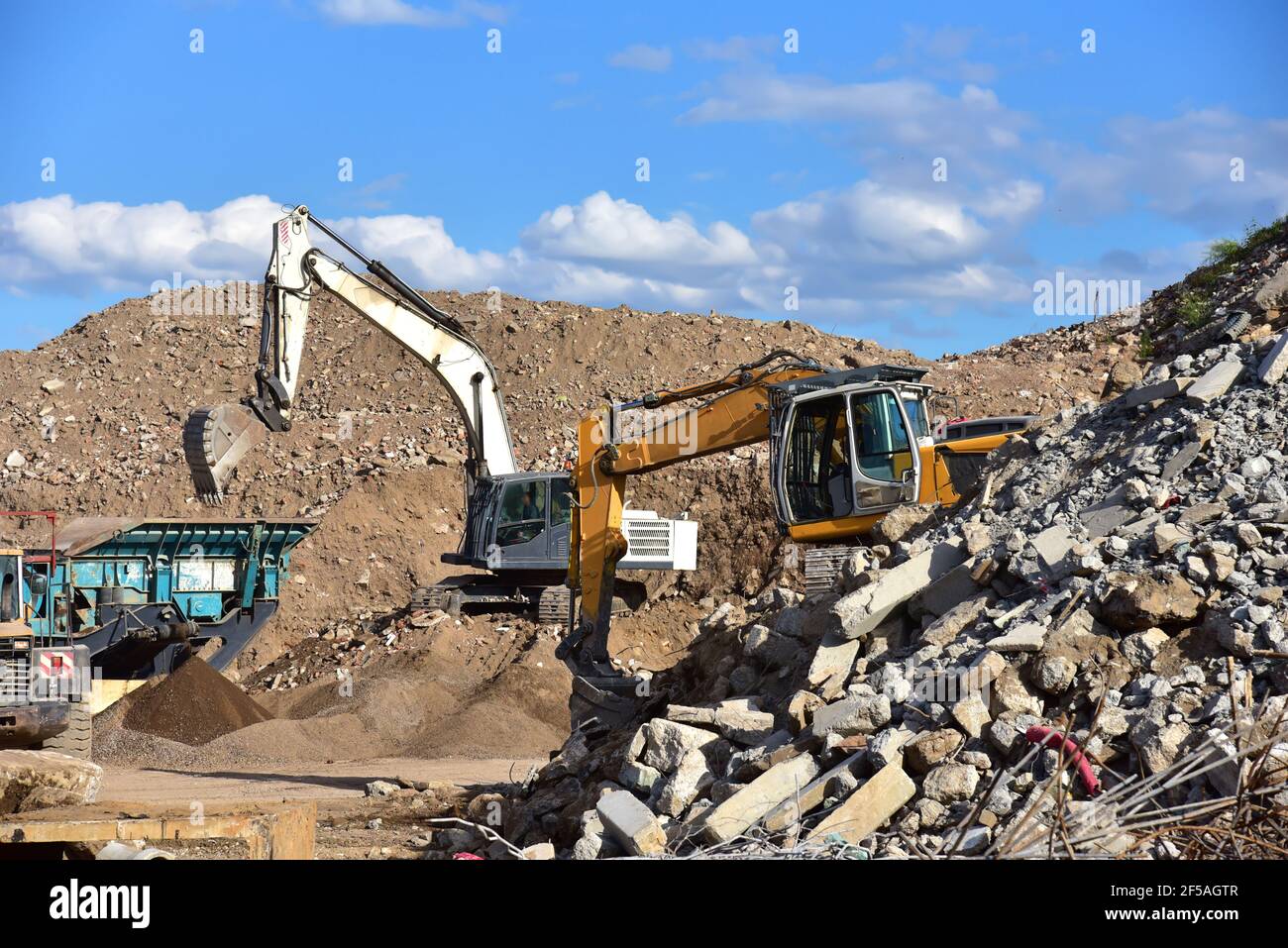 Excavator load concrete waste into a mobile jaw crusher machine at at ...