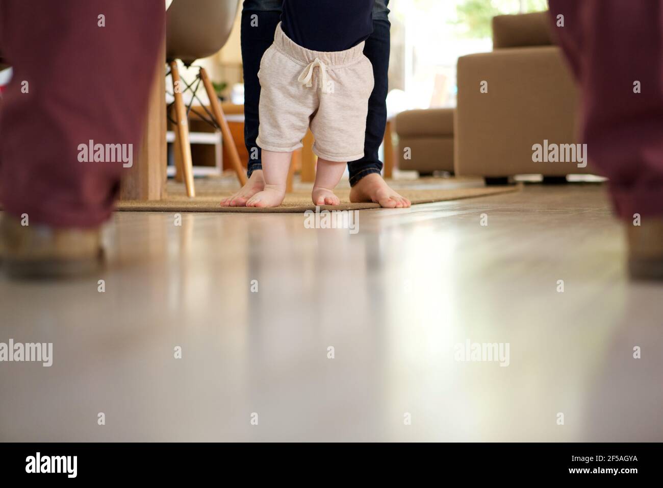 Close up portrait of little baby boy learning to walk with mother help ...