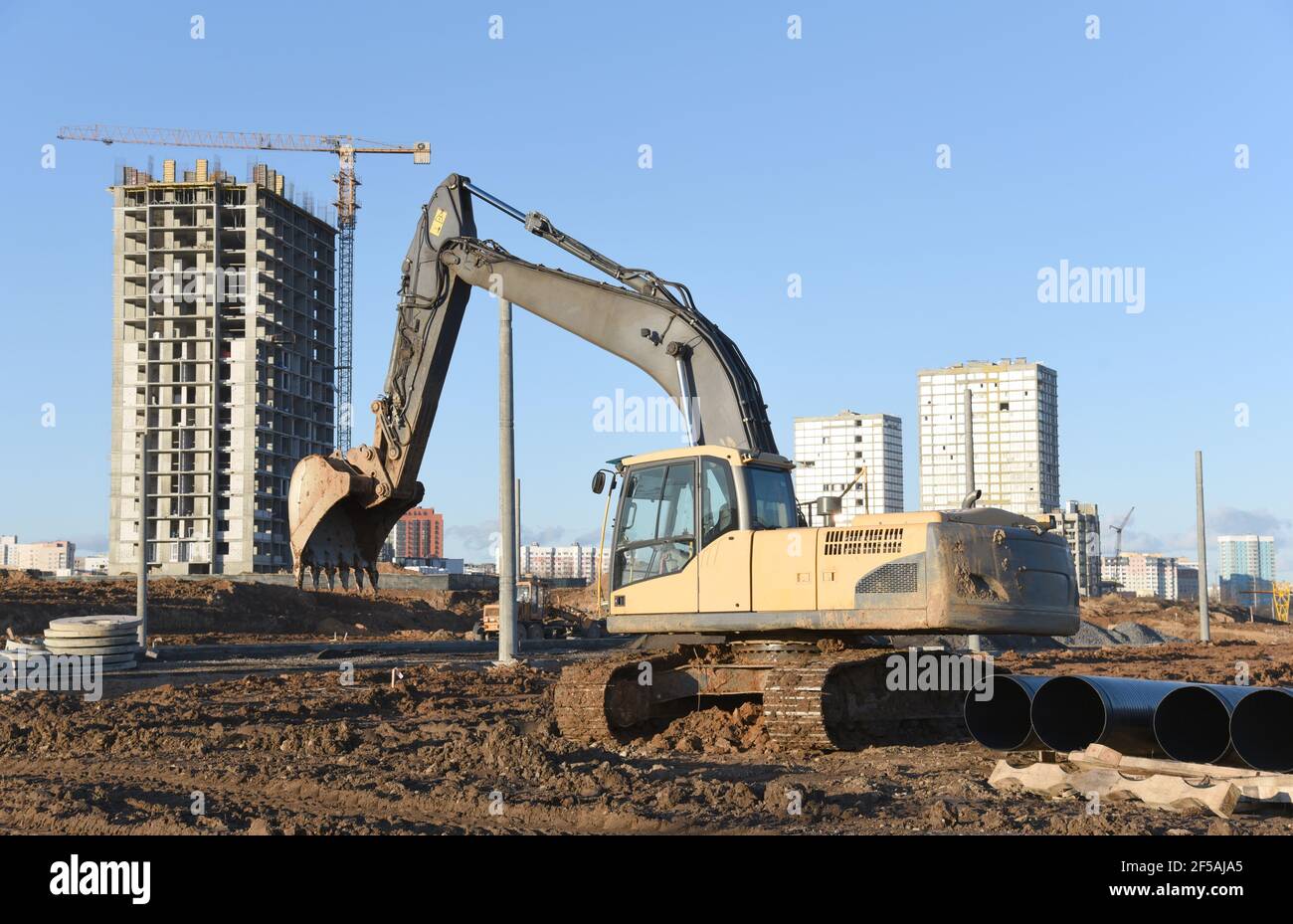 Excavator working at construction site. Backhoe digs ground for the ...