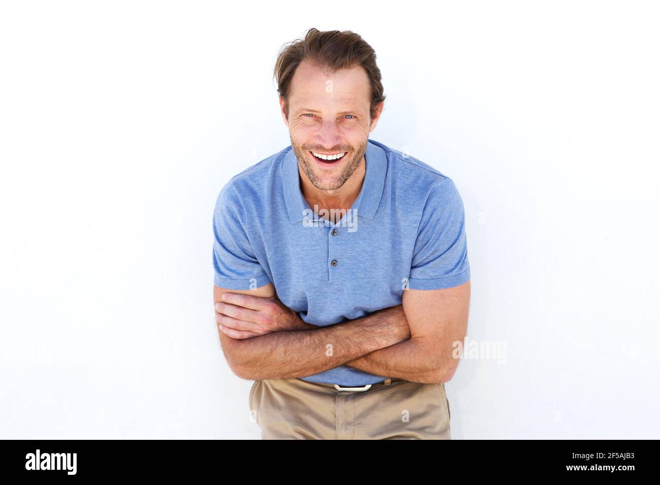 Portrait of male fashion model laughing against white wall Stock Photo ...
