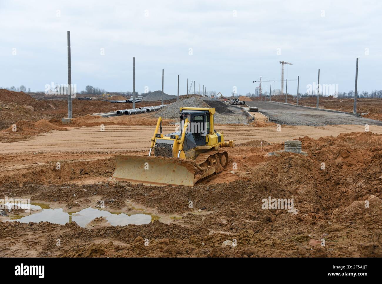 Bulldozer moves gravel during on road work at construction site. Dozer ...