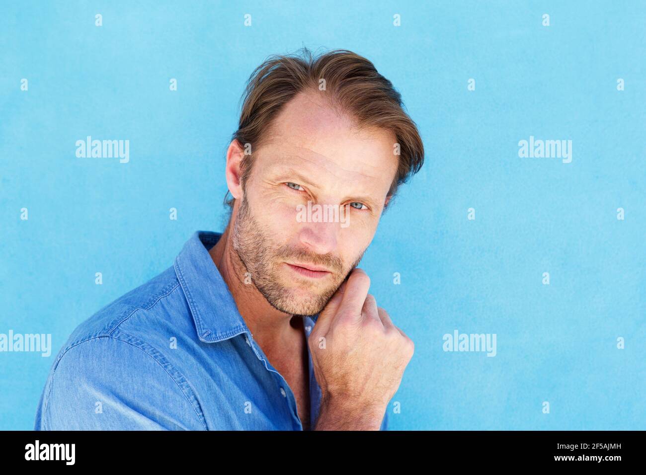 Close up portrait of attractive male model thinking with hand to chin ...