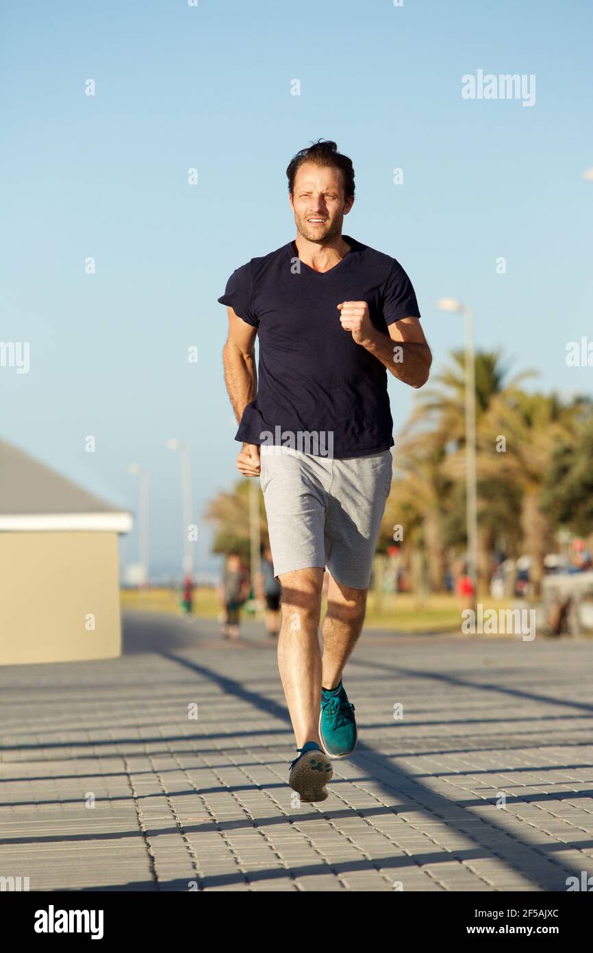 Full body portrait of healthy man running outdoors Stock Photo - Alamy