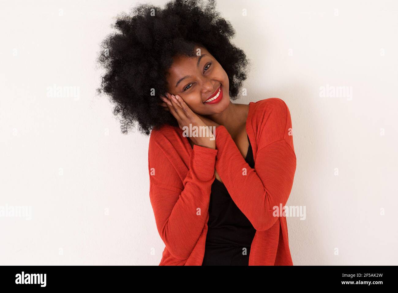Portrait of cute african american woman smiling with head on hands ...