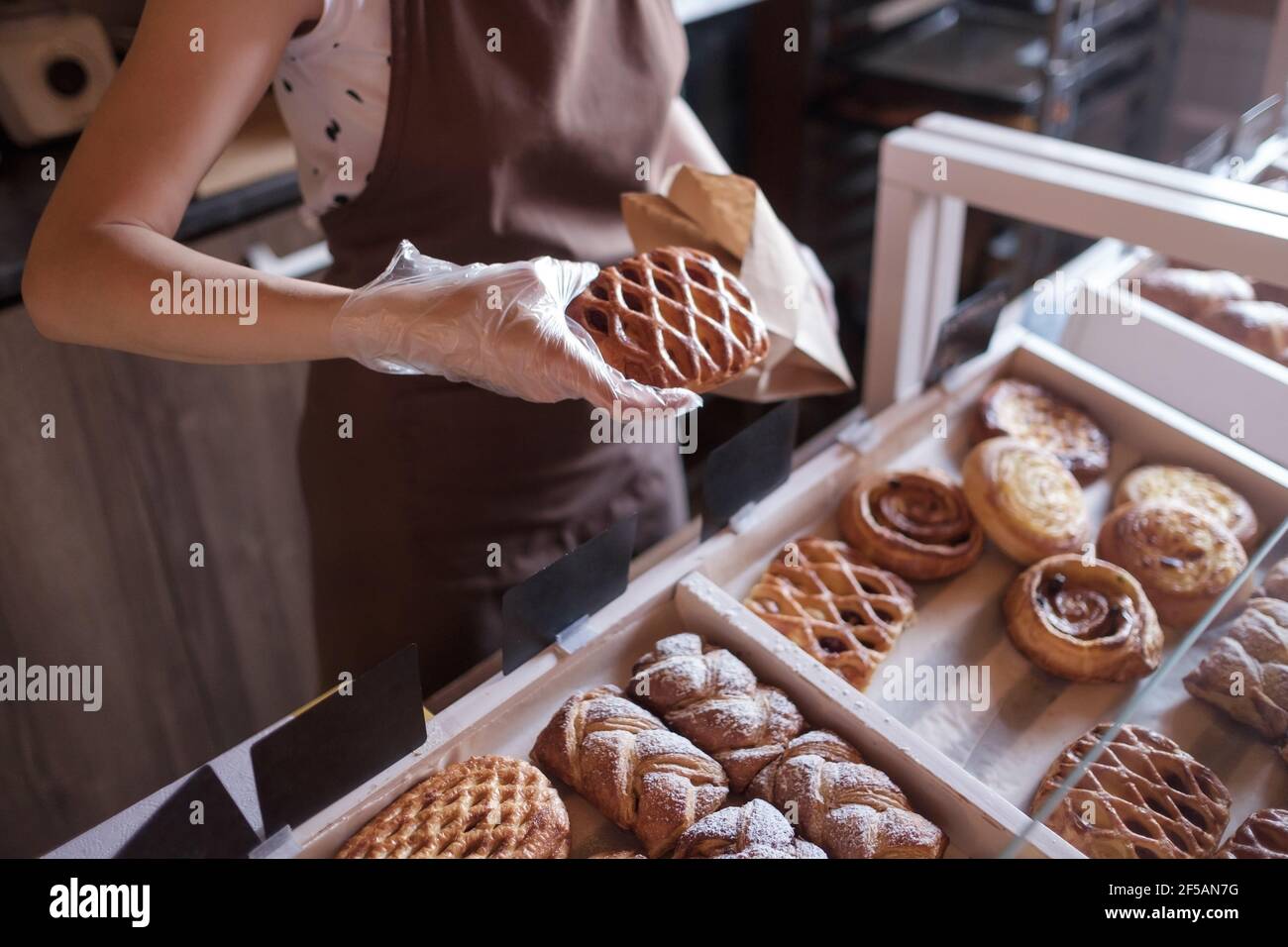 Female bakery worker with freshly baked bun Stock Photo - Alamy