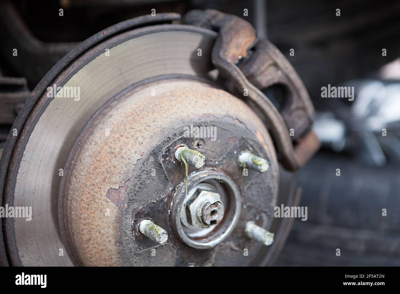 Old thin ventilated brake disk with used brake pads are ready for ...