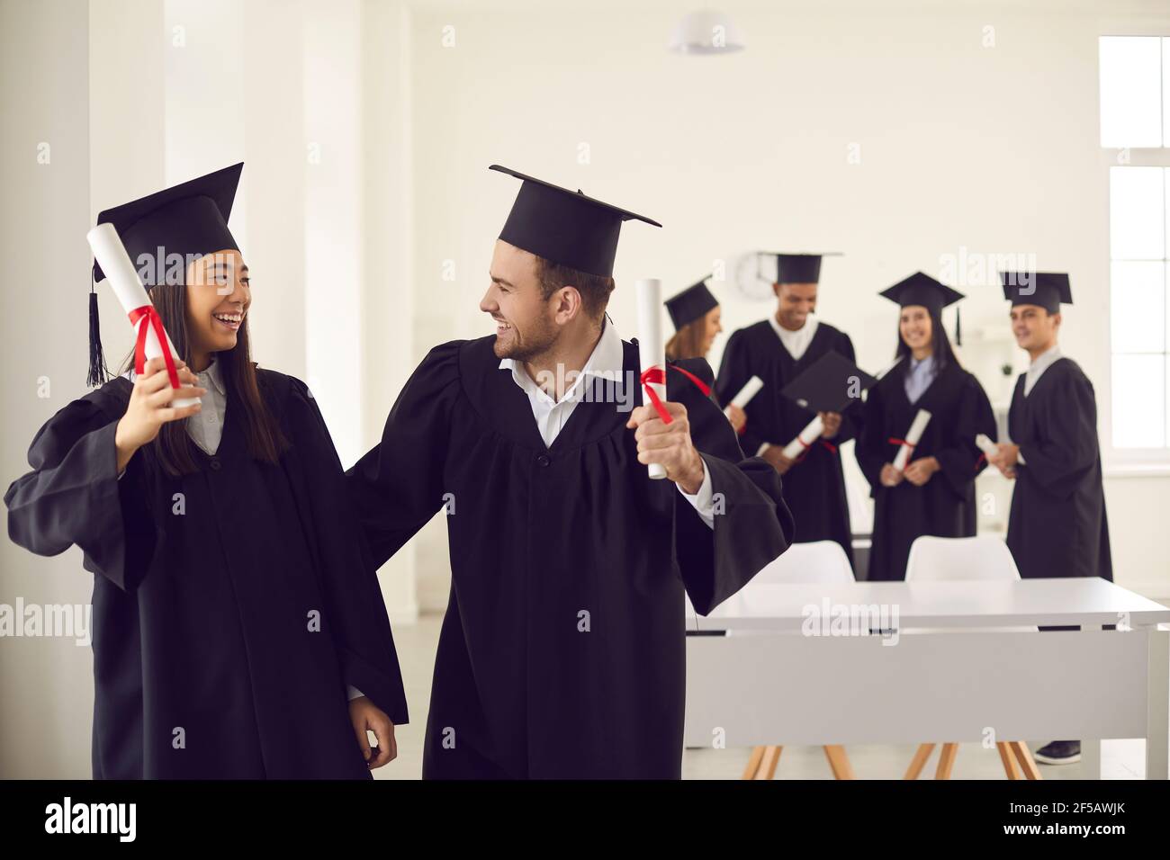 Young happy couple classmates asian girl and caucasian boy celebrating ...