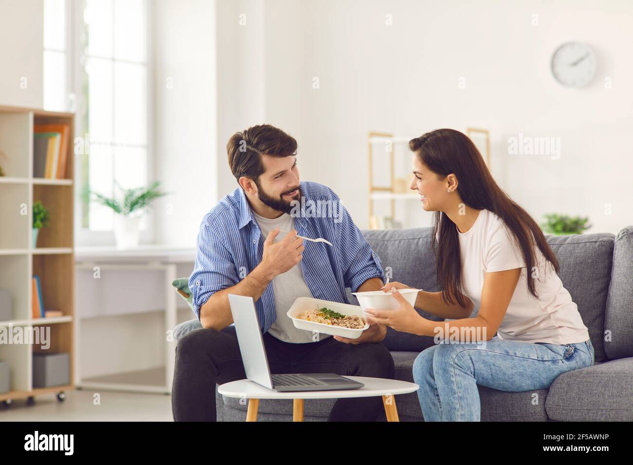 Young smiling couple office workers sitting and eating healthy cooked ...