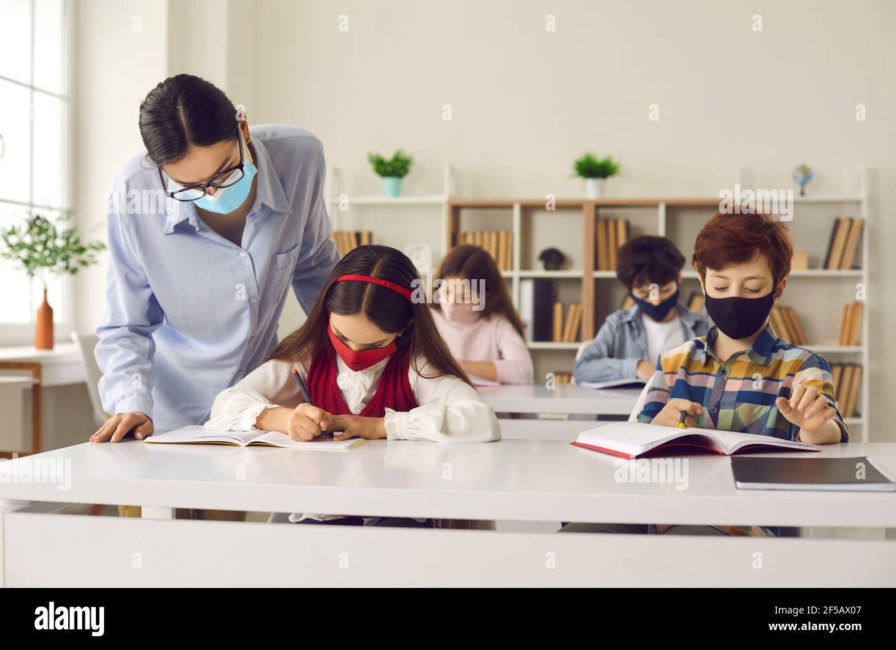 School students and teacher wearing face masks in class to protect from ...