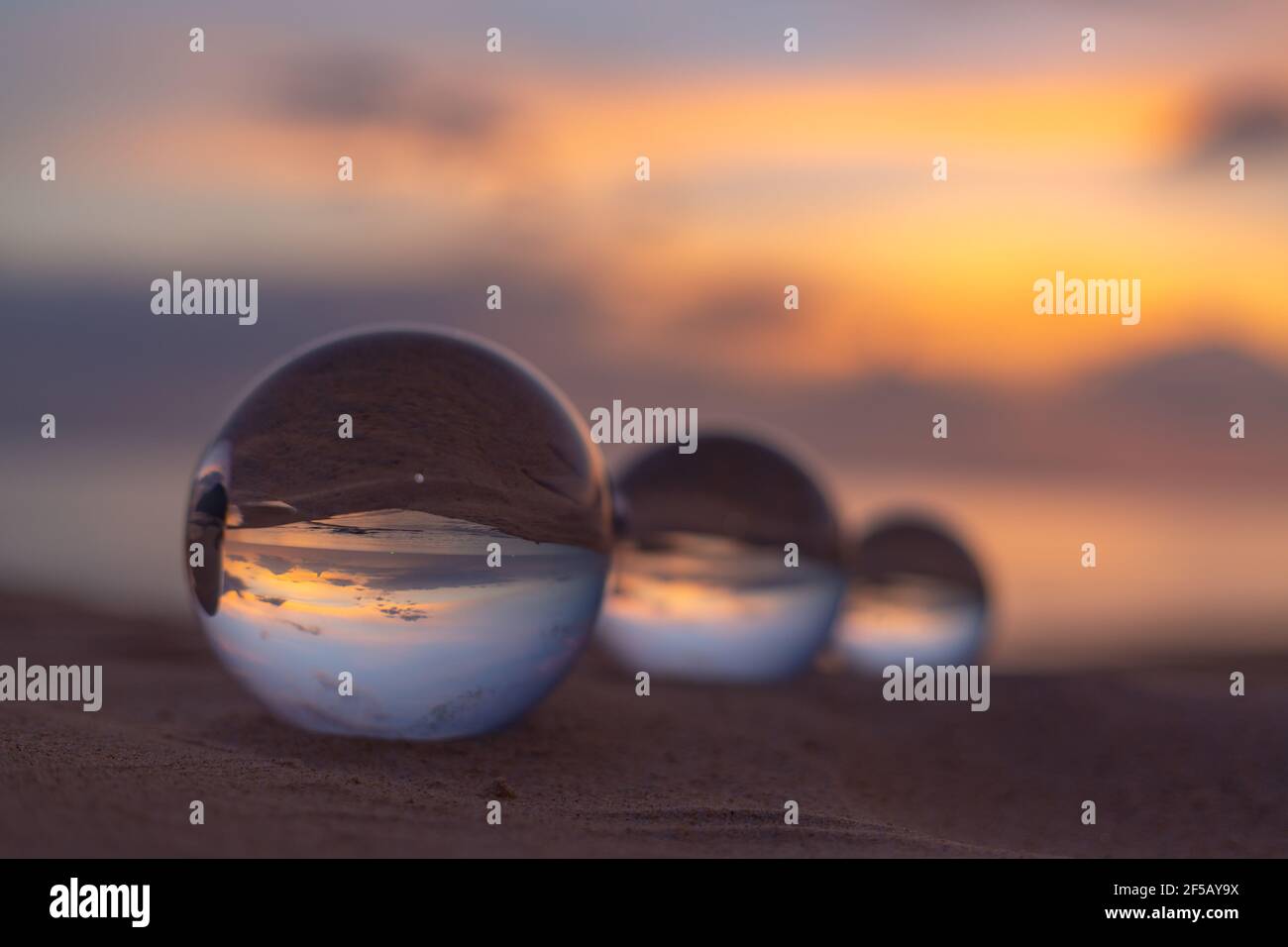 Three clear crystal balls of three sizes are sphere reveals seascape ...