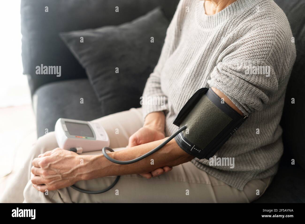 Senior woman checking blood pressure level at home, older female ...