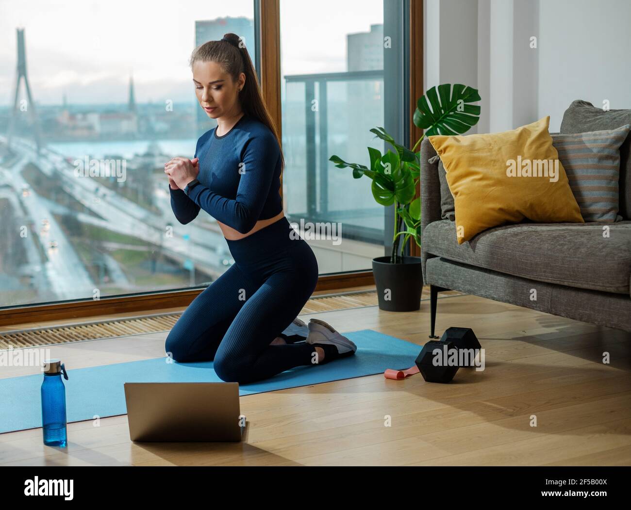 Brunette practices exercise with workout video on laptop Stock Photo ...