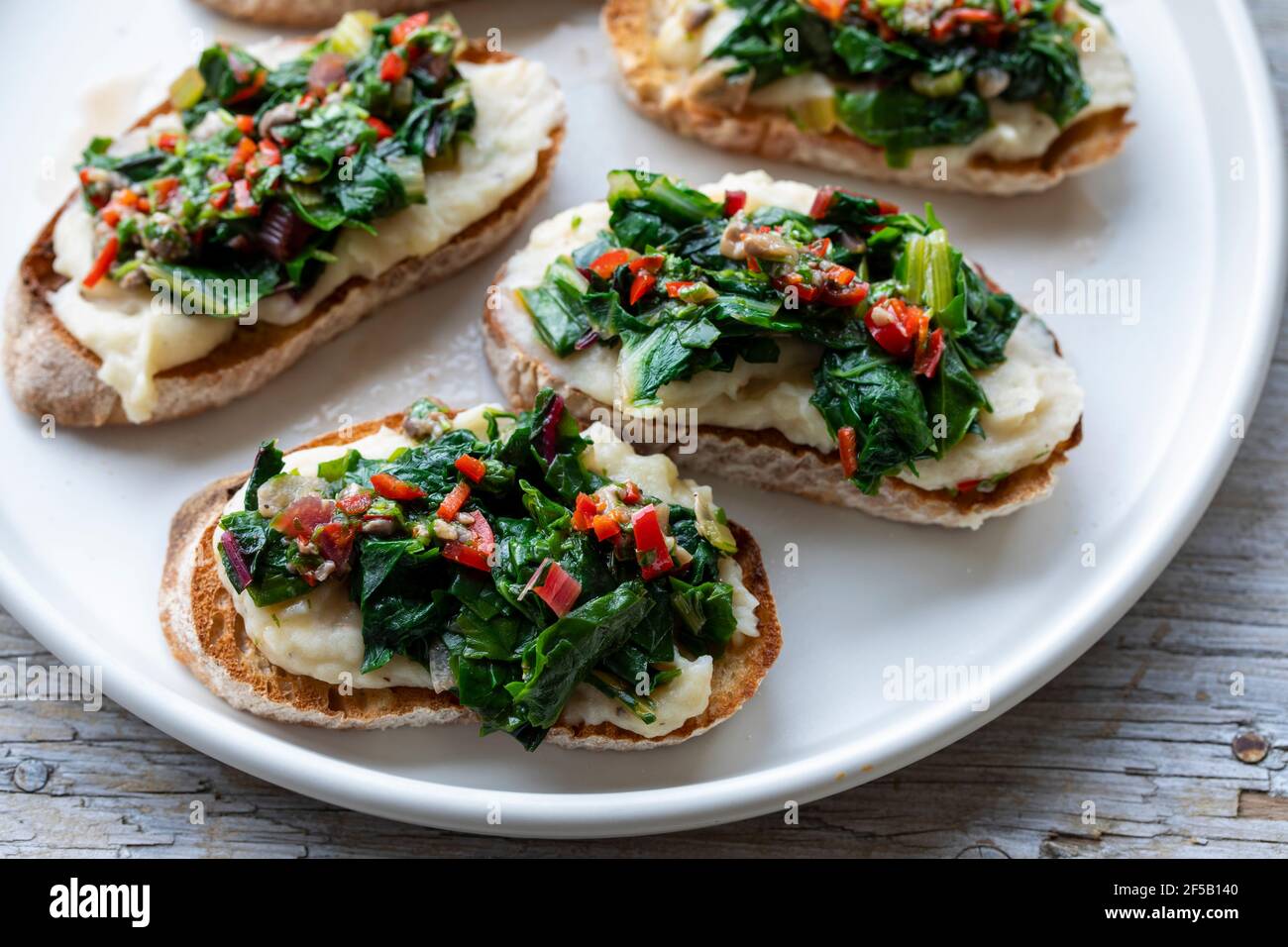 Crostini with white bean puree and Swiss chard Stock Photo - Alamy