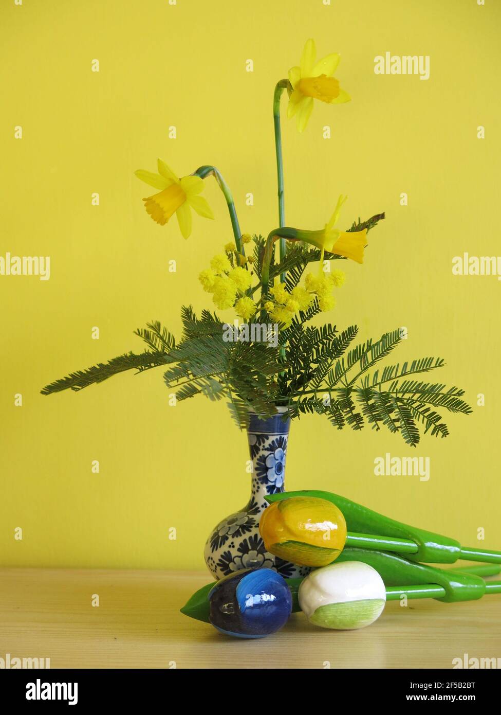 A Dutch themed floral arrangement with miniature daffodils and mimosa ...