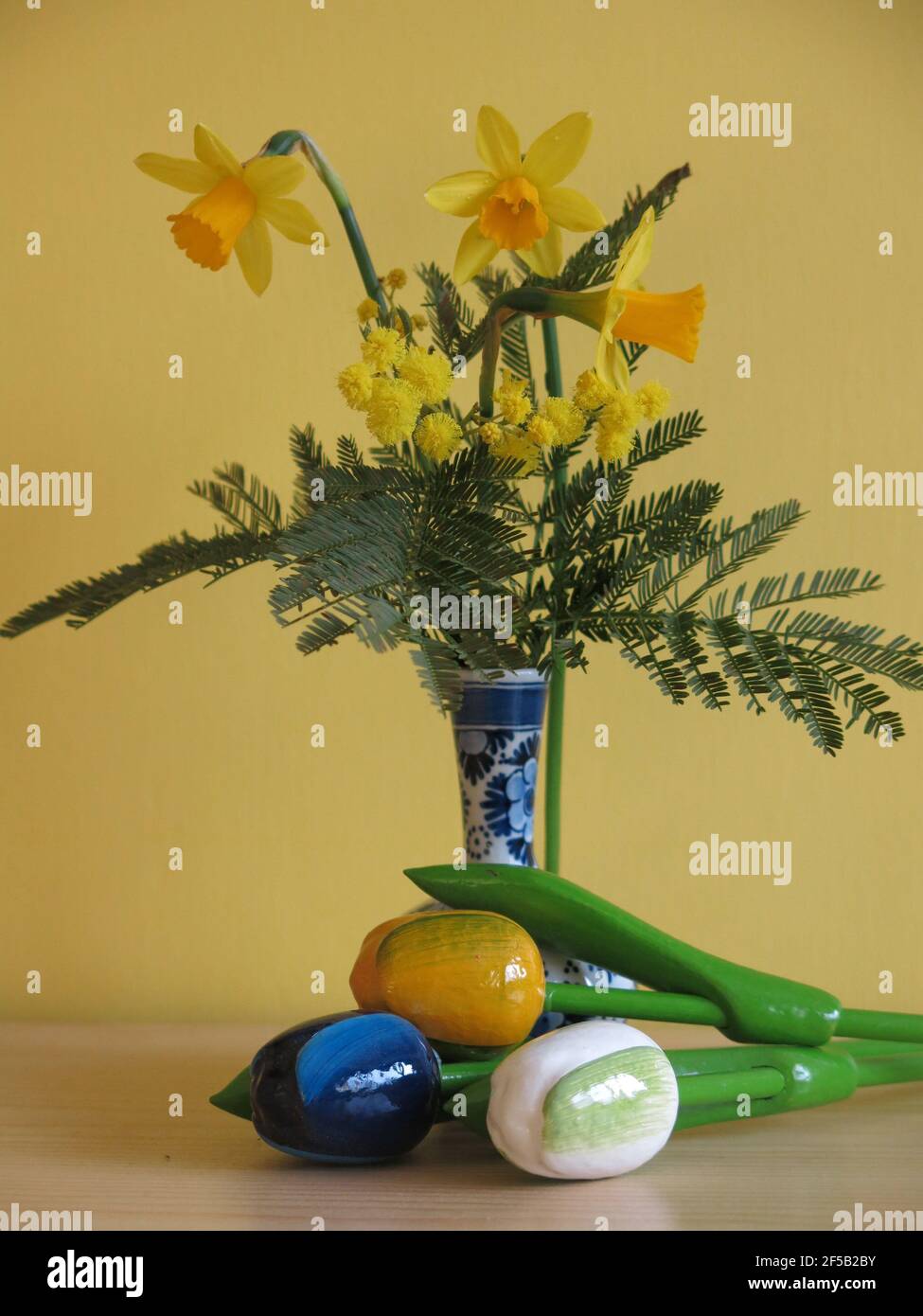 A Dutch themed floral arrangement with miniature daffodils and mimosa ...