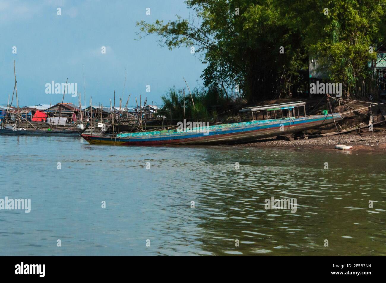 Traditional wooden fishing boat in Asia, it is partly on dry land, in ...