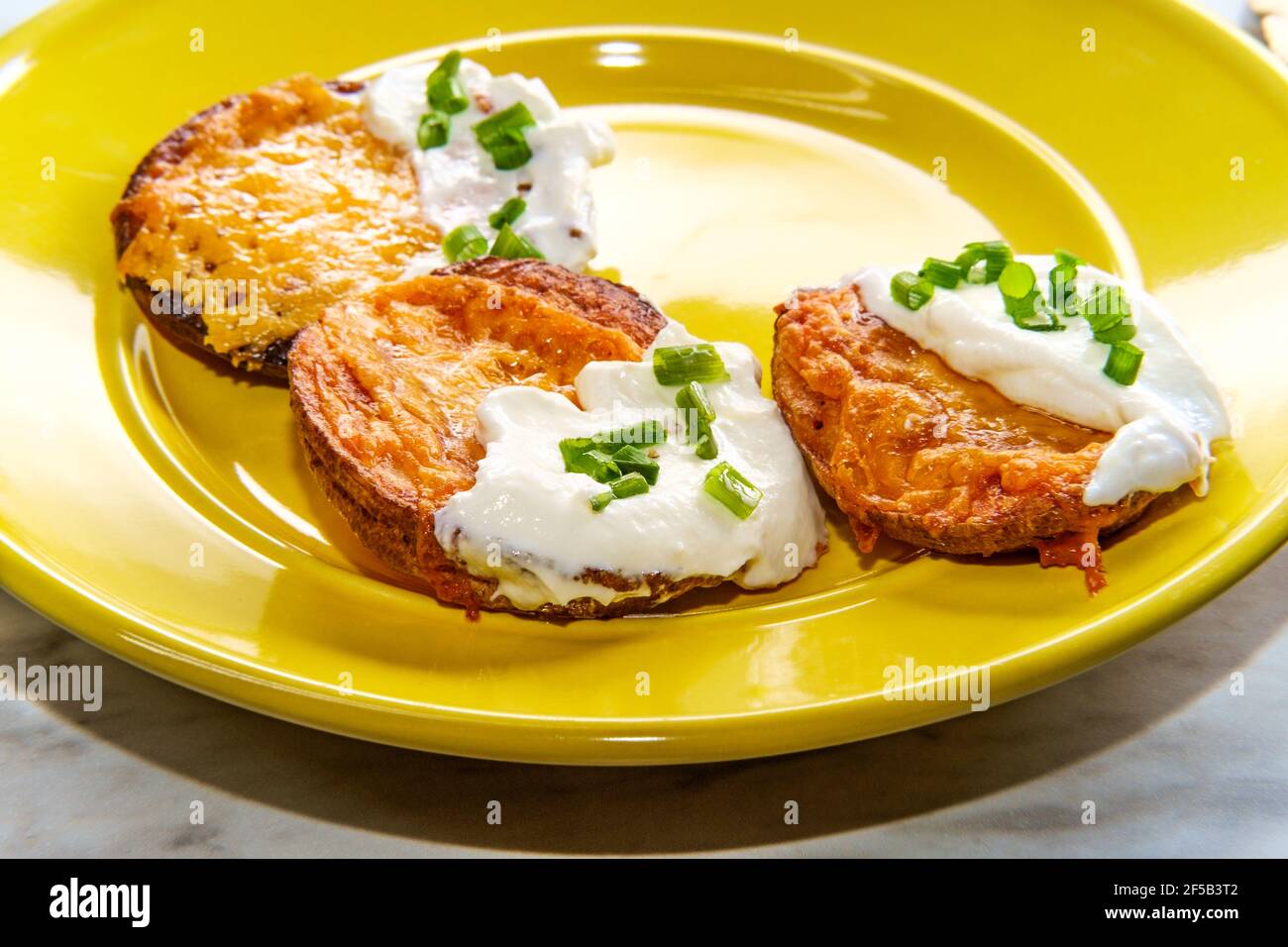 Cheesy oven roasted cheddar potato rounds with sour cream and chive ...