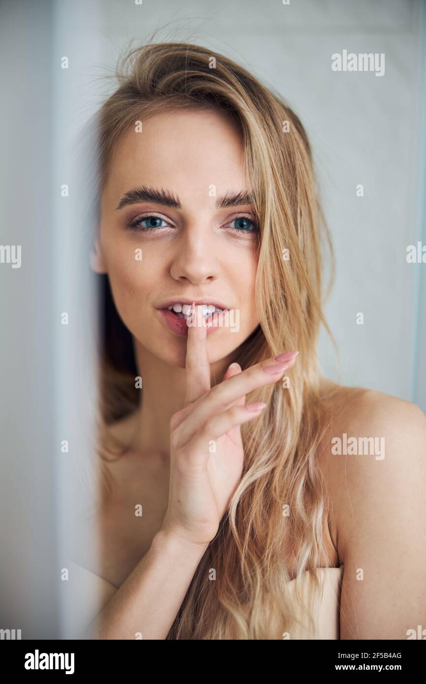 Cute young female making a silence sign Stock Photo - Alamy