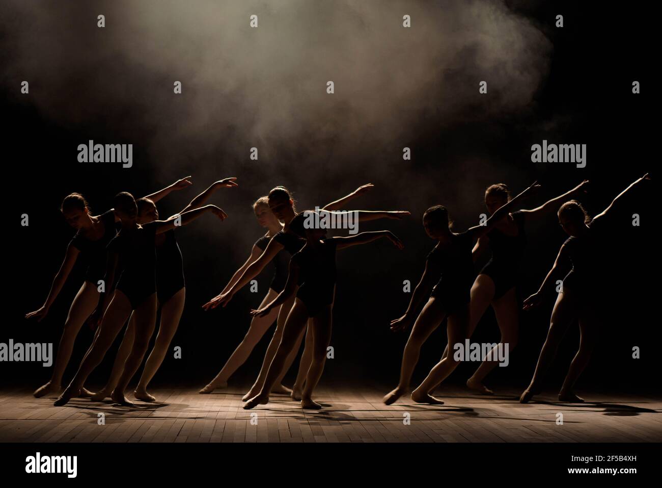 Young ballerinas rehearsing in the ballet class. They perform different ...