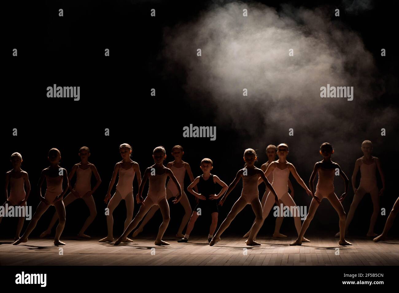Young ballerinas rehearsing in the ballet class. They perform different ...