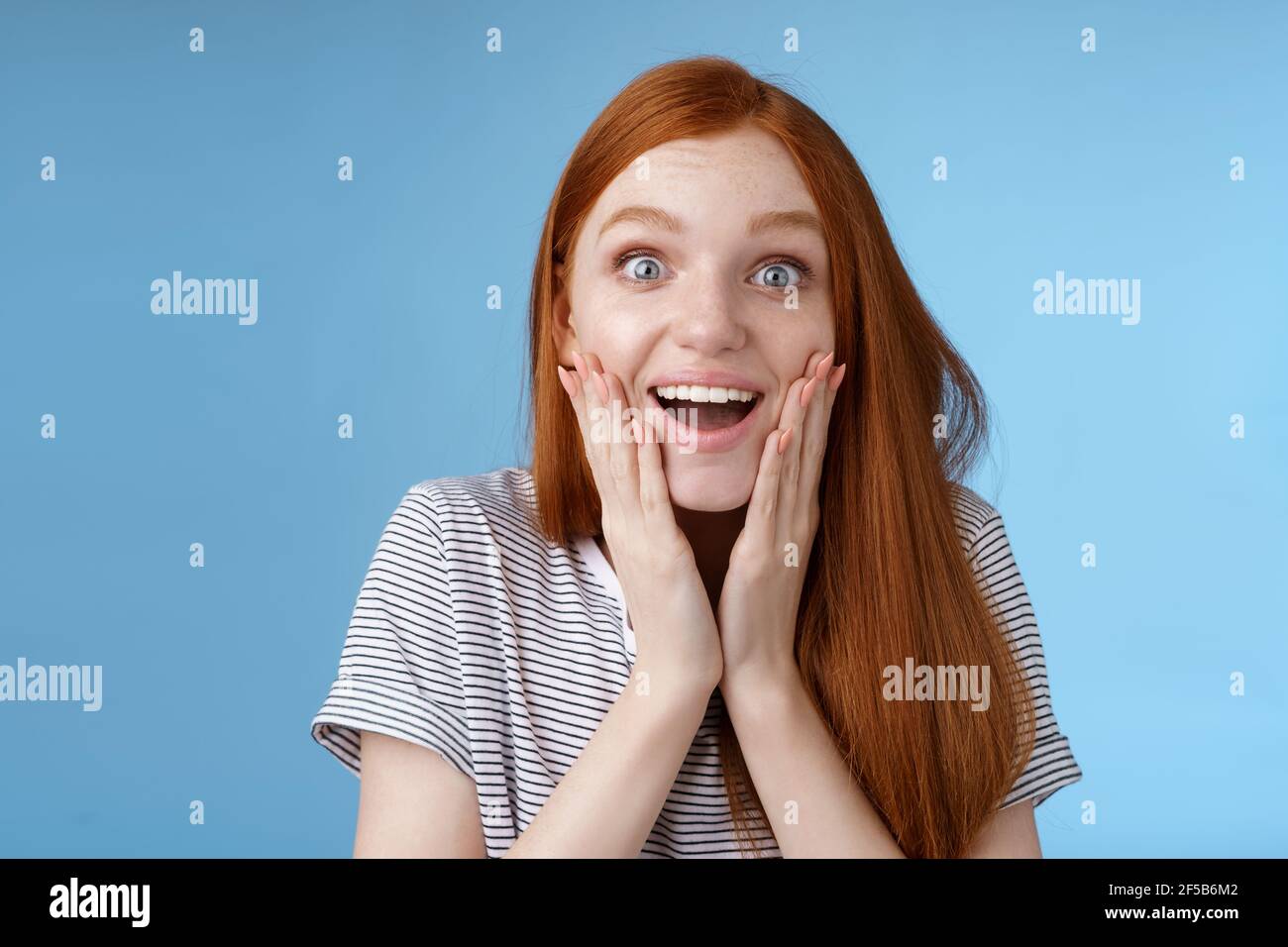 Amused happy dreamy young excited redhead female fan looking fascinated ...