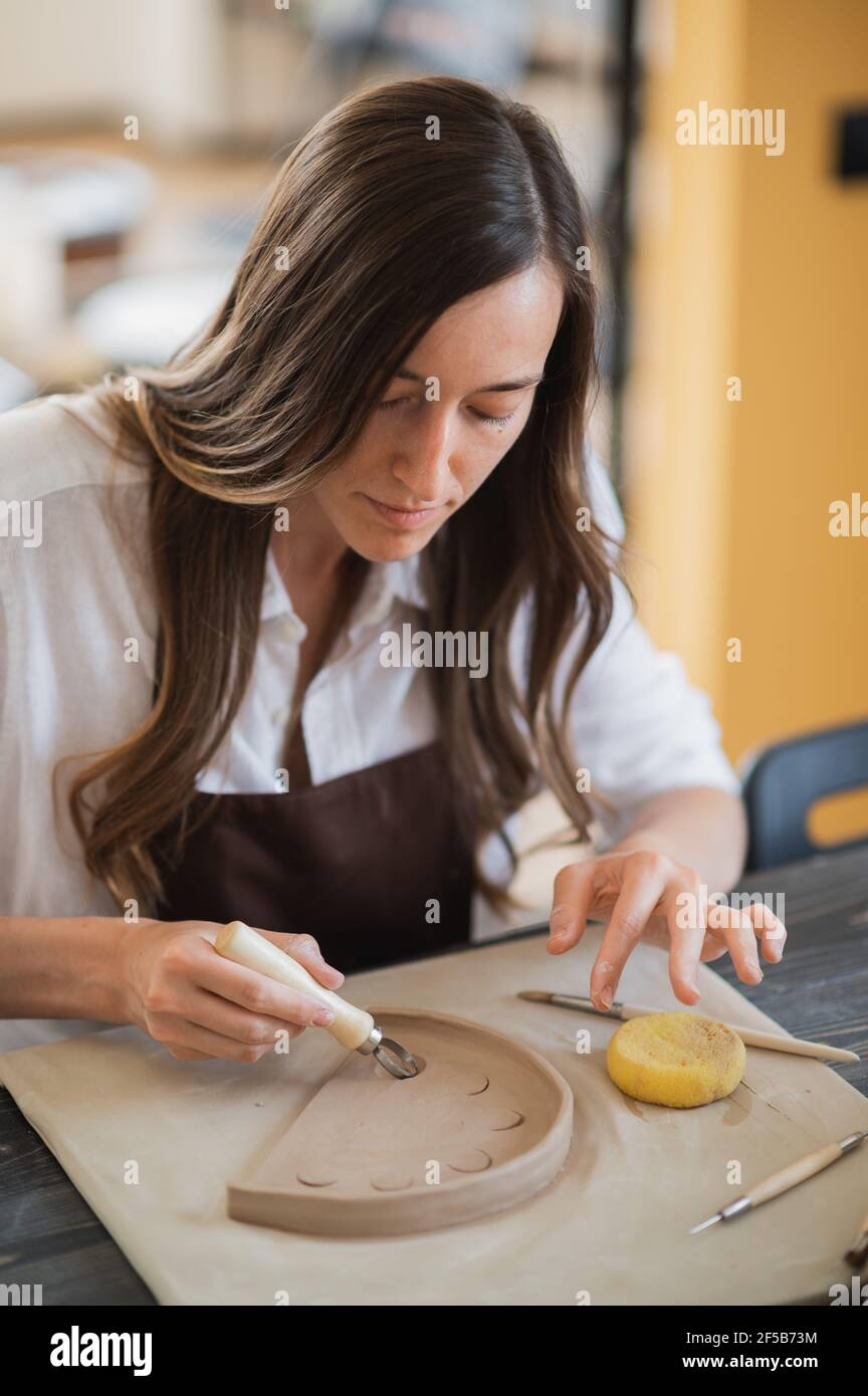 Craftsman hands connect the clay parts made of raw clay, master fingers ...