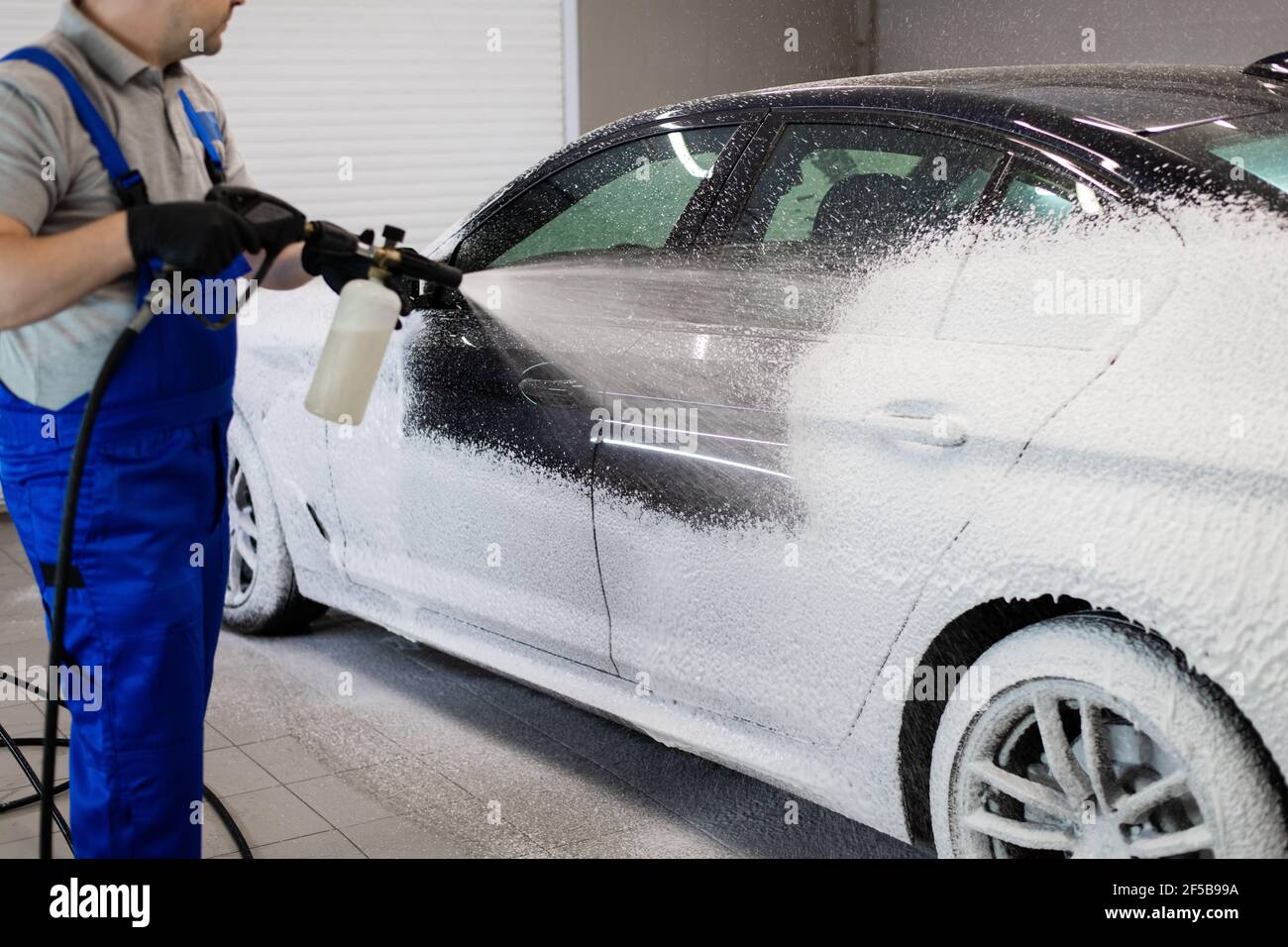 Car washing process. Foaming detergent covers side of the car, clean it ...