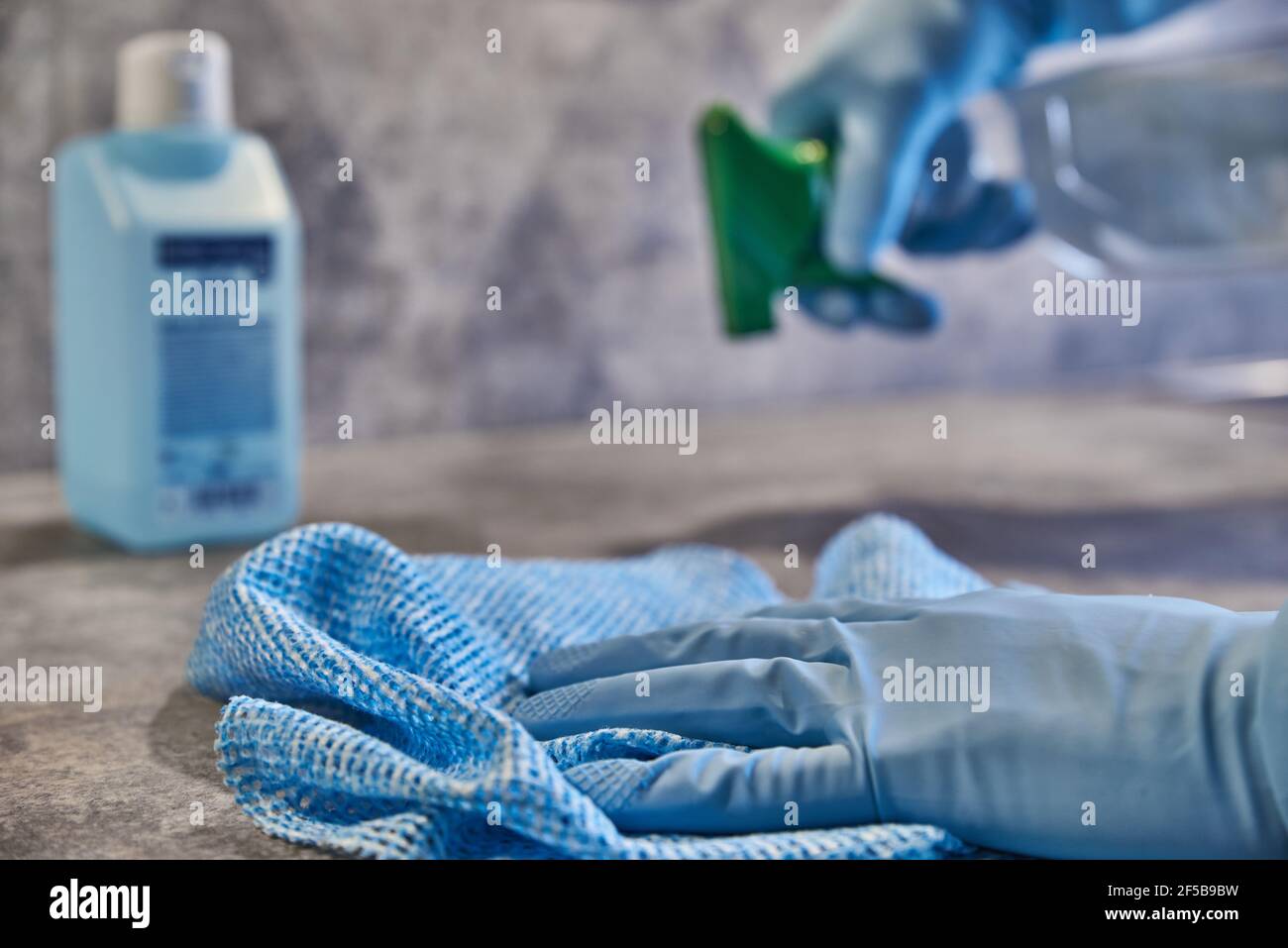 Person disinfecting a table with disinfectant. Cleaning a surface with ...