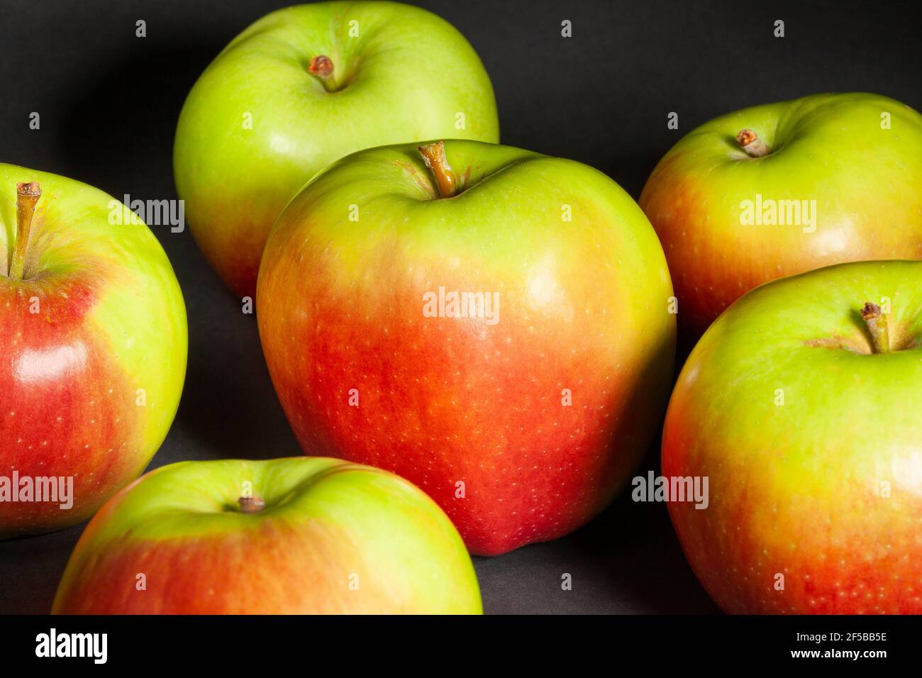 red green apple on black background Stock Photo - Alamy