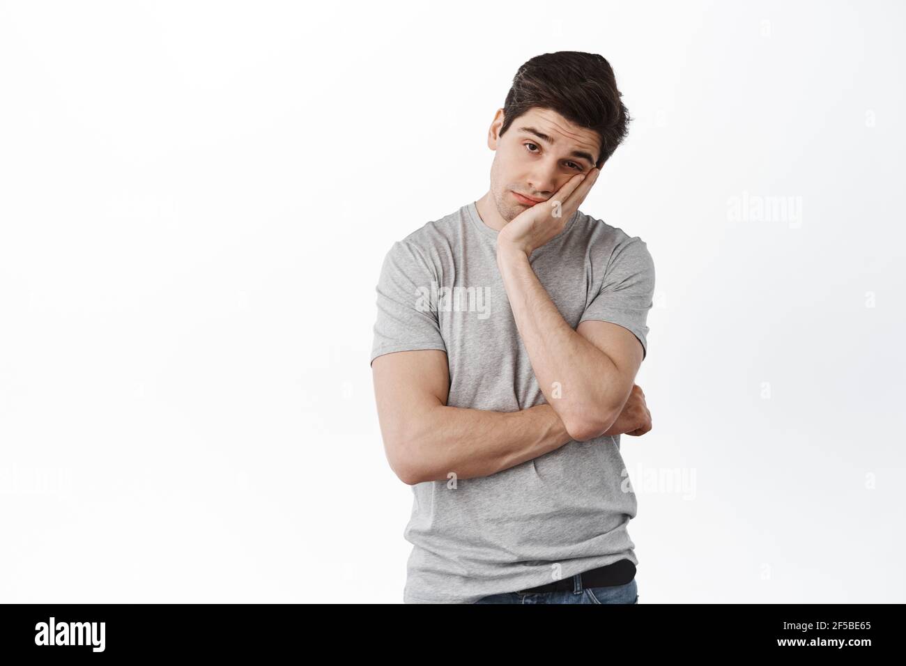 Portrait of bored and sleepy adult man lean on palm, look tired at ...