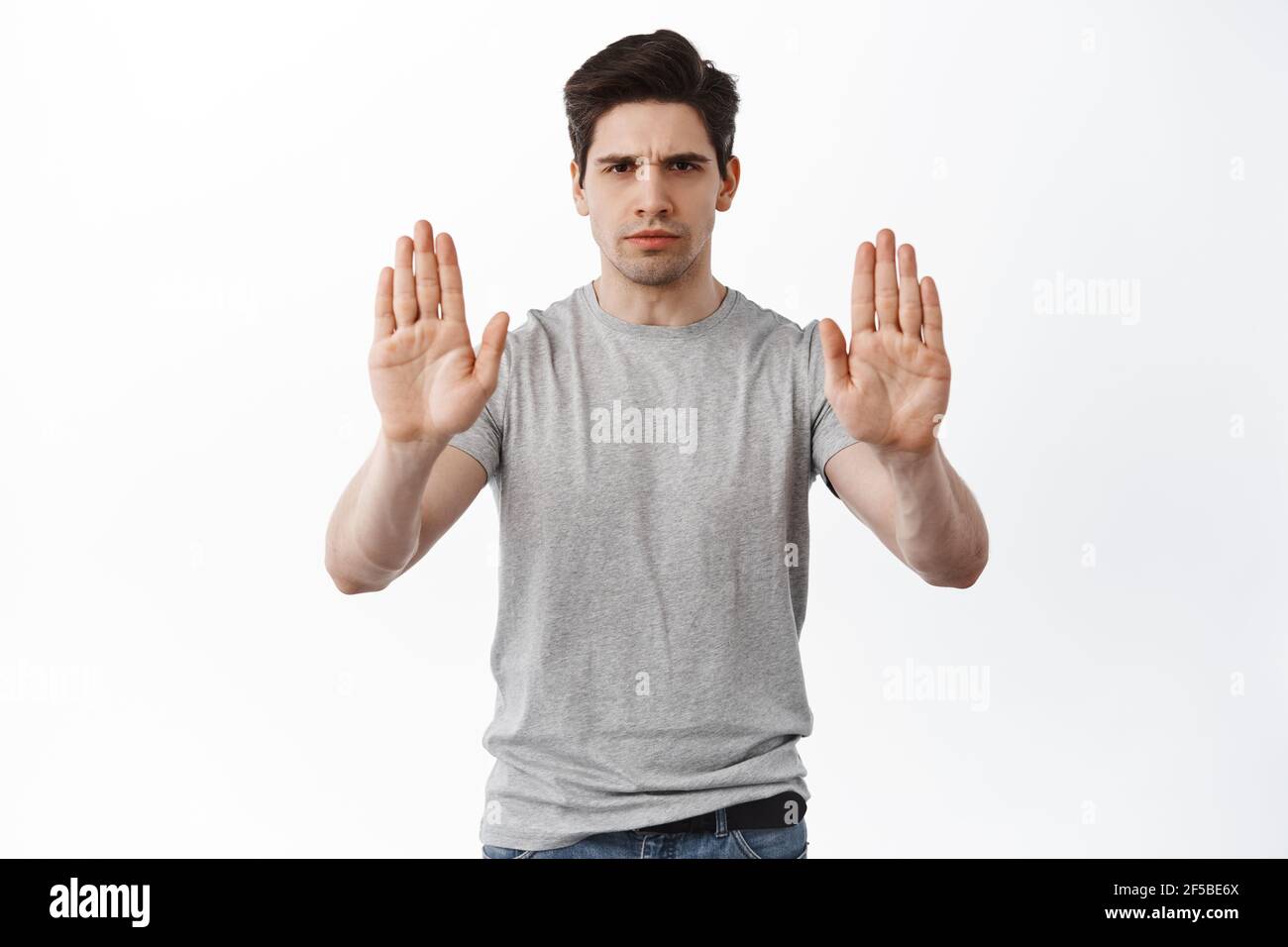 Stop it, keep distance. Serious frowning man showing block refusal ...